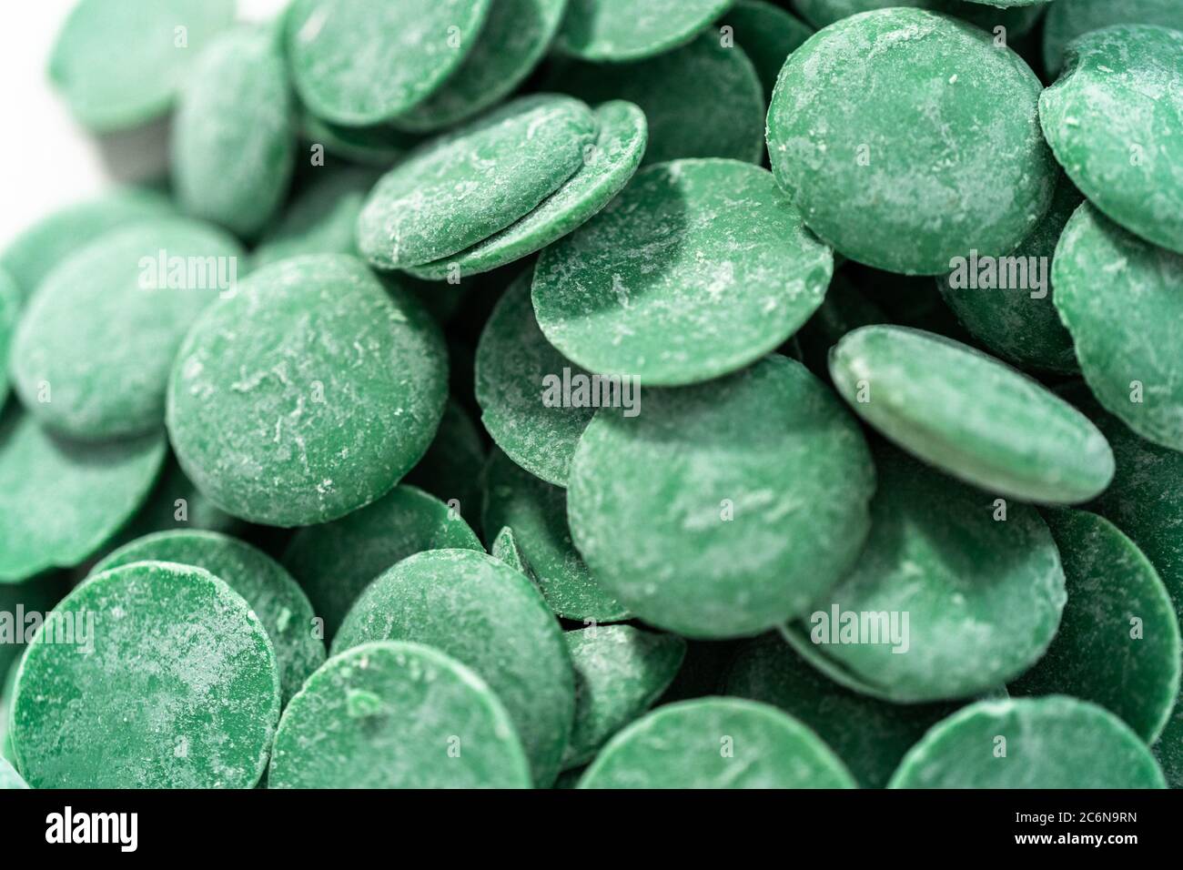 Green round chocolate chips for melting chocolate shapes on a white ...