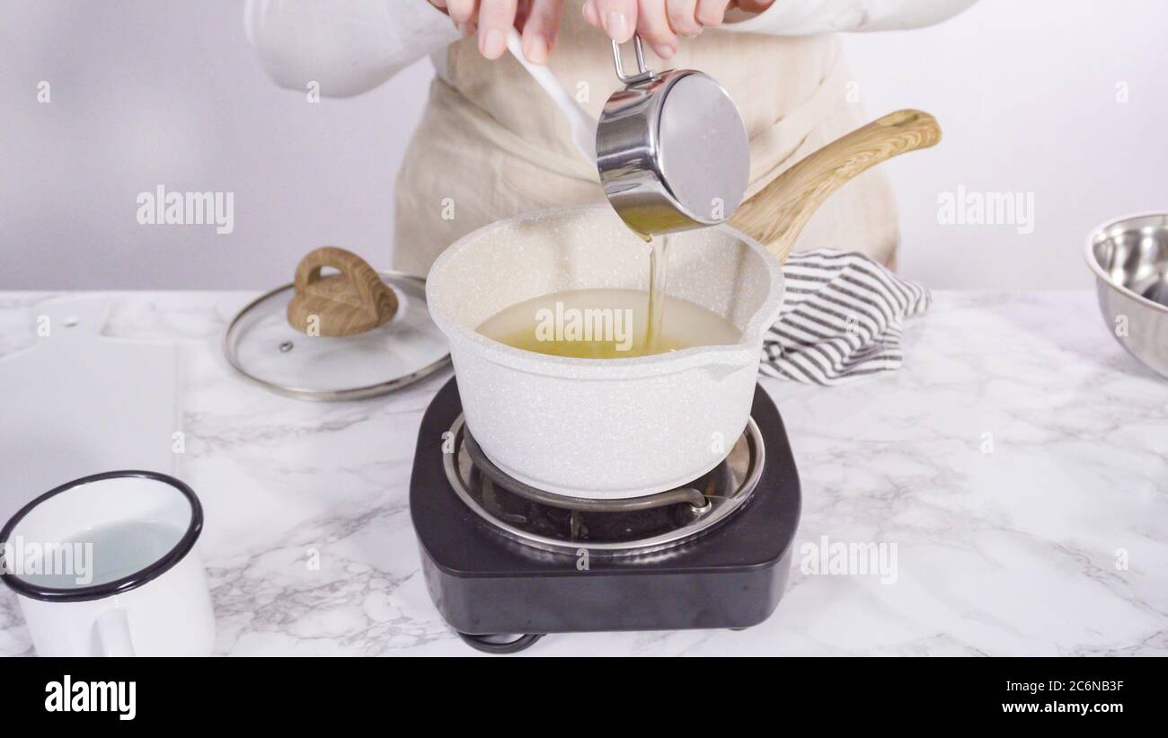 Step by step. Caramelizing sugar in a small cooking pot over the small ...
