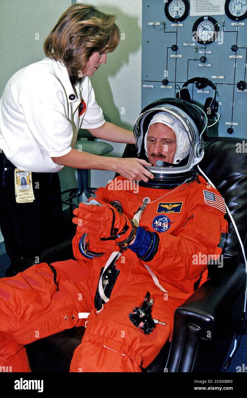 STS-82 Mission Specialist Joseph R. "Joe" Tanner dons his launch and ...