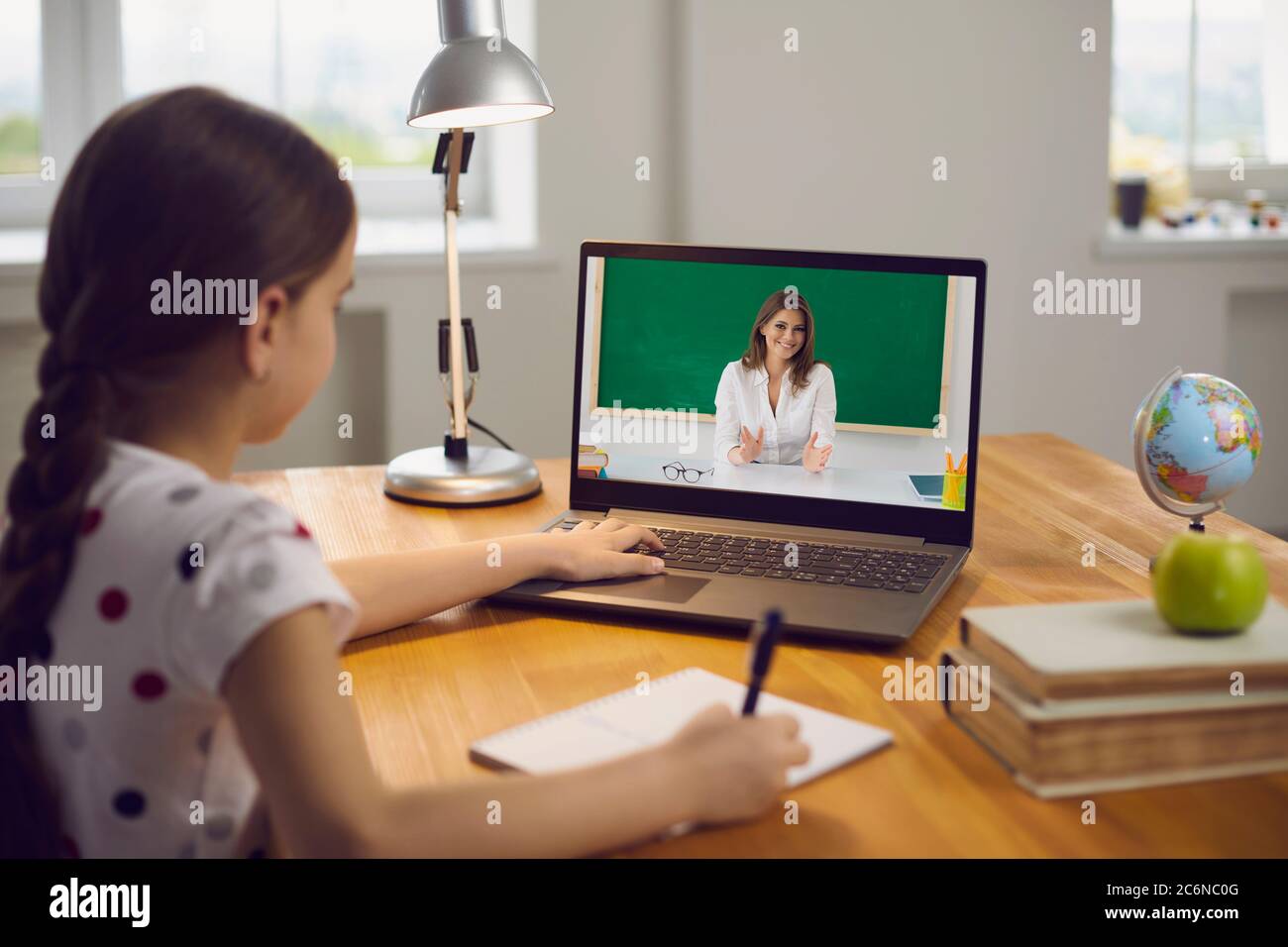 Remote education of children. Little girl watching a video lesson from ...