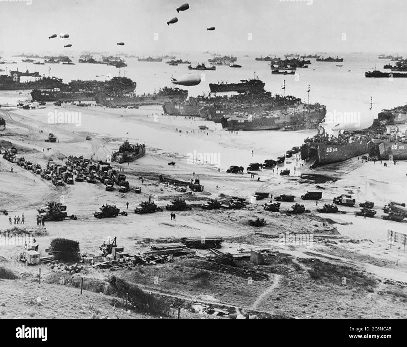 A bird's-eye view of landing craft, barrage balloons and Allied troops ...
