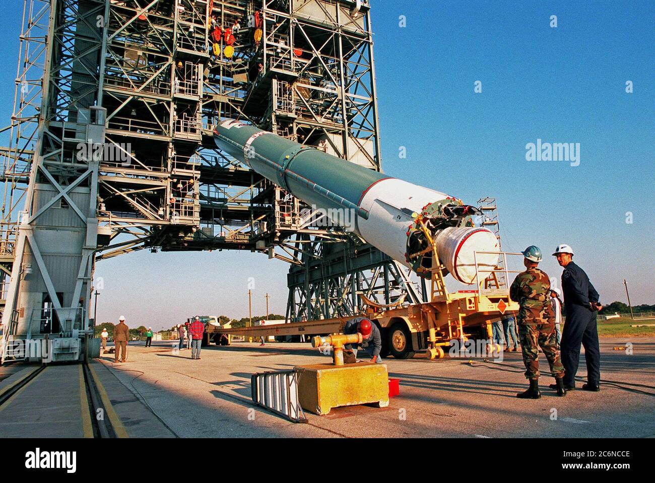 On Pad 17A at Cape Canaveral Air Station, cables lift the Delta II ...