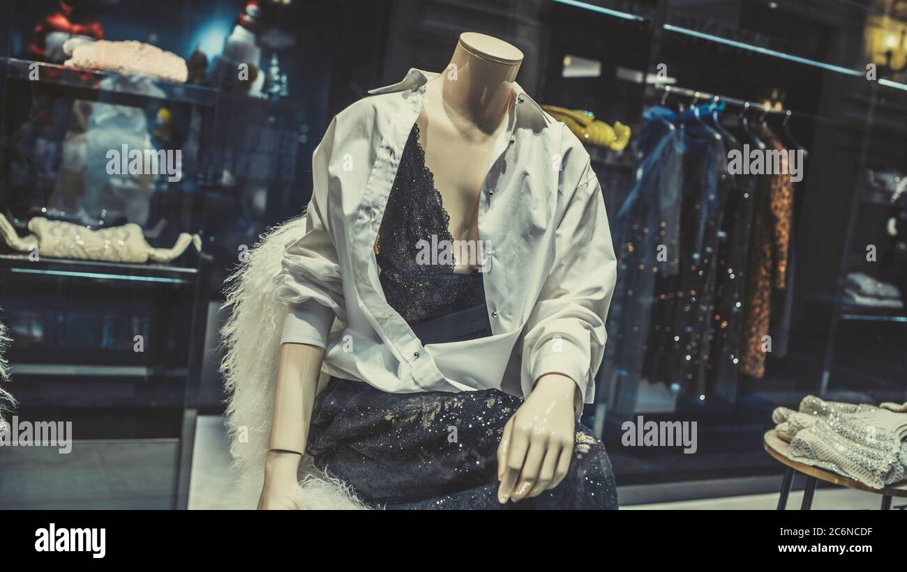 A mannequin stands in the window of a clothing store. Clothing store ...