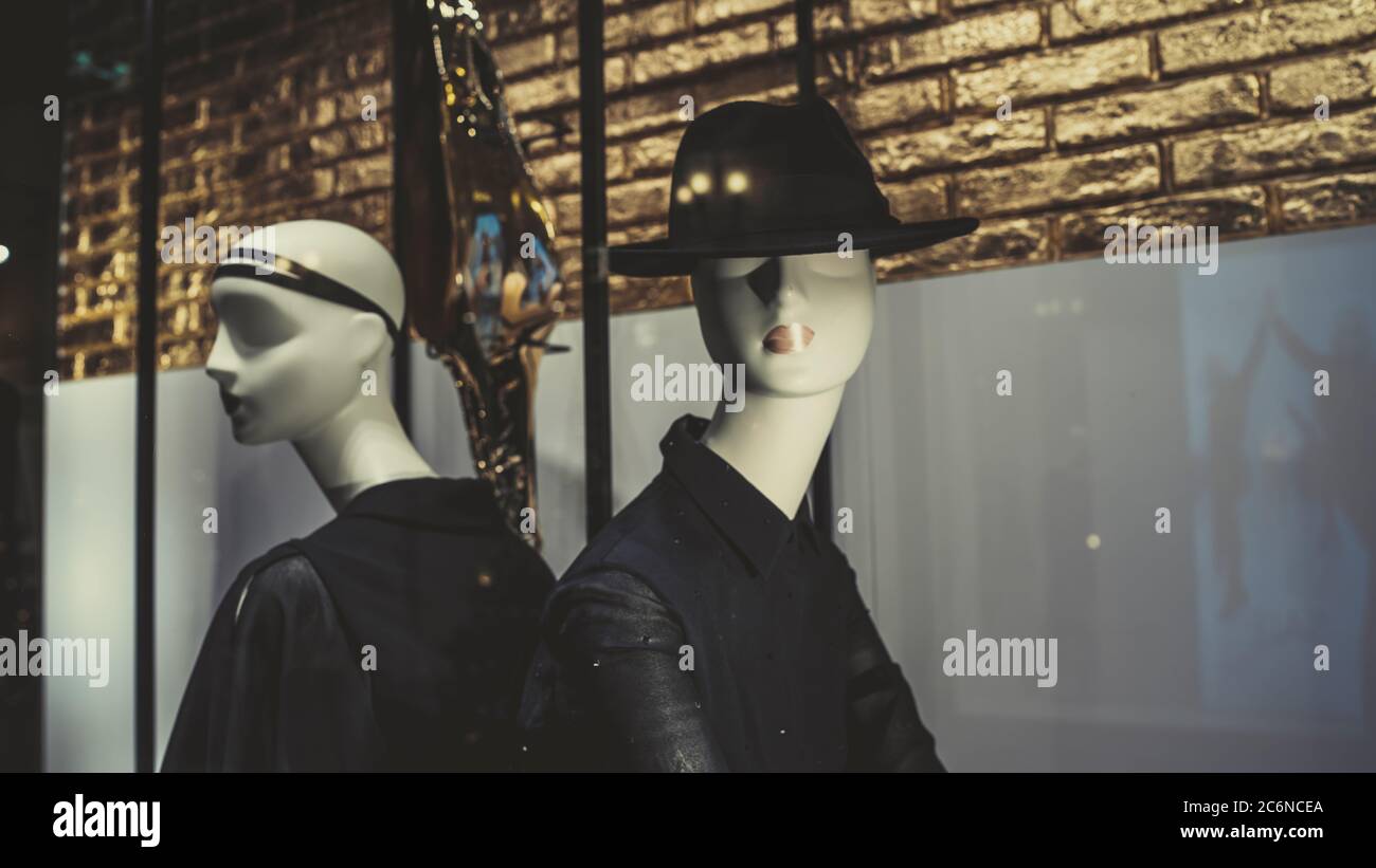 A mannequin stands in the window of a clothing store. Clothing store ...