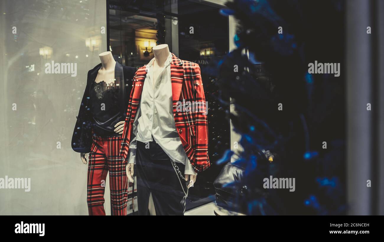 A mannequin stands in the window of a clothing store. Clothing store ...