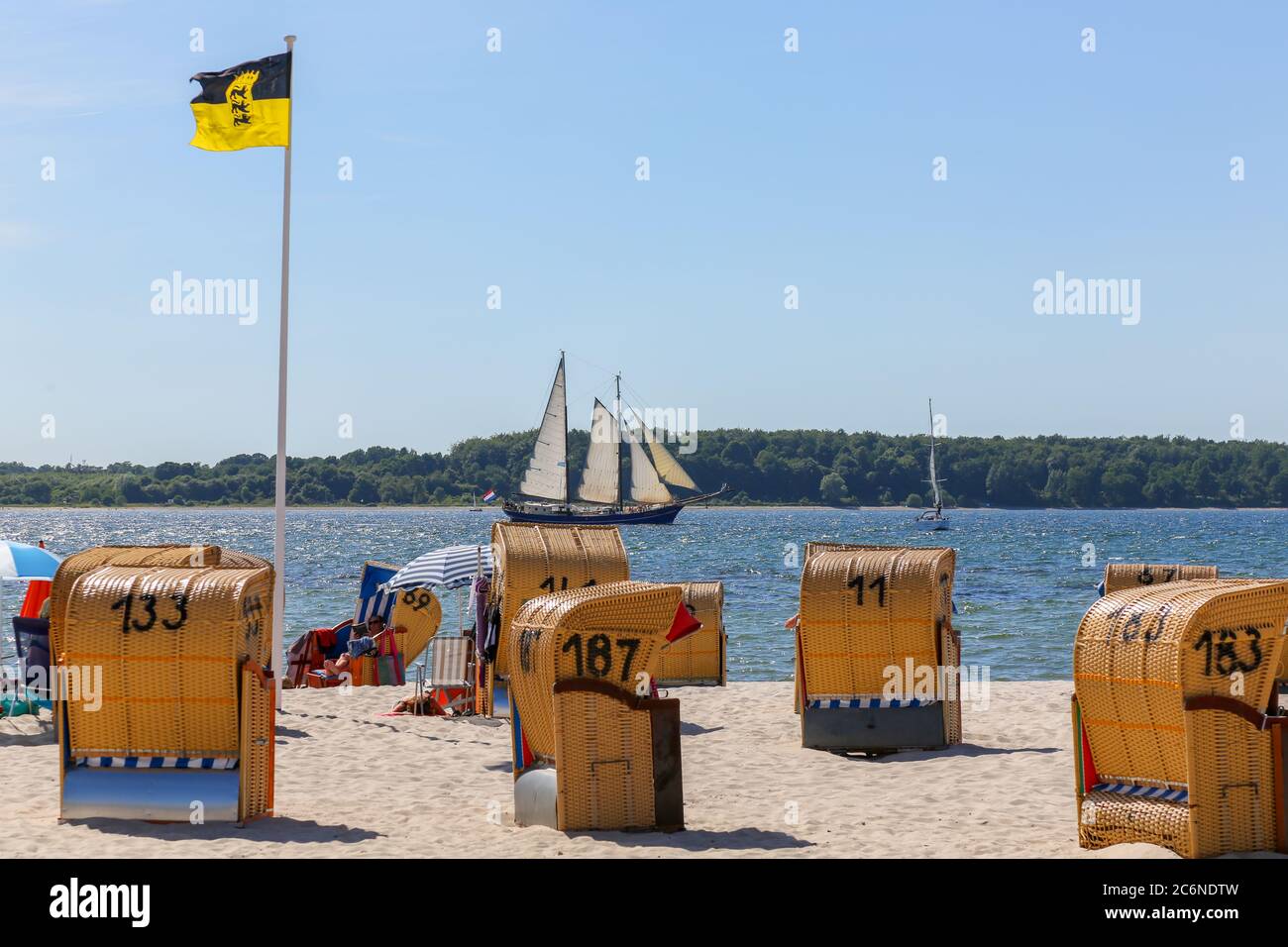 Sunny Beach Scene with Strandkorb Chairs and Sailboats. Leboe, Germany ...