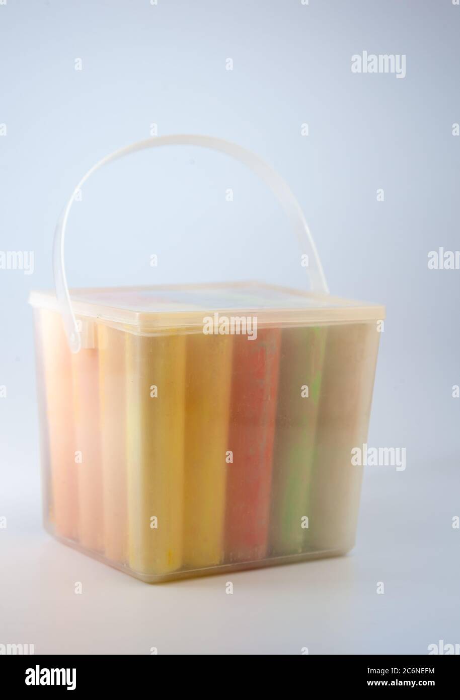 Colorful chalks in plastic bucket isolated on white background. Close ...