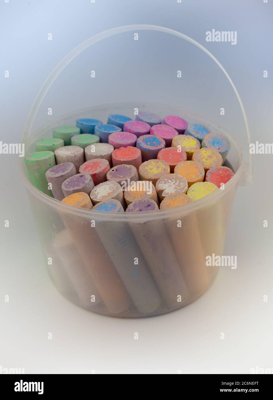 Colorful chalks in plastic bucket isolated on white background. Close ...