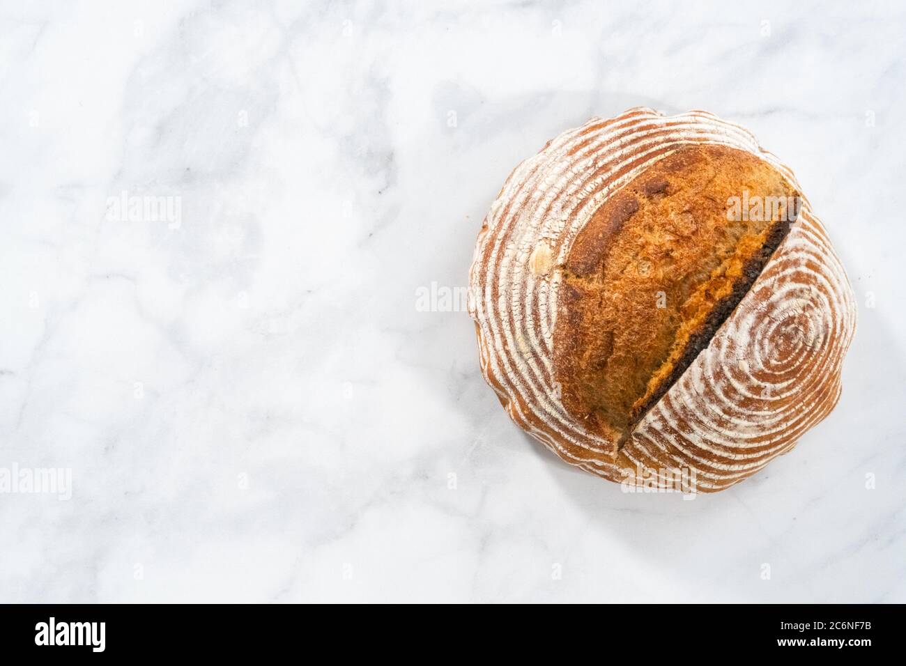 Flat lay. Freshly baked loaf of a wheat sourdough bread with marks from ...