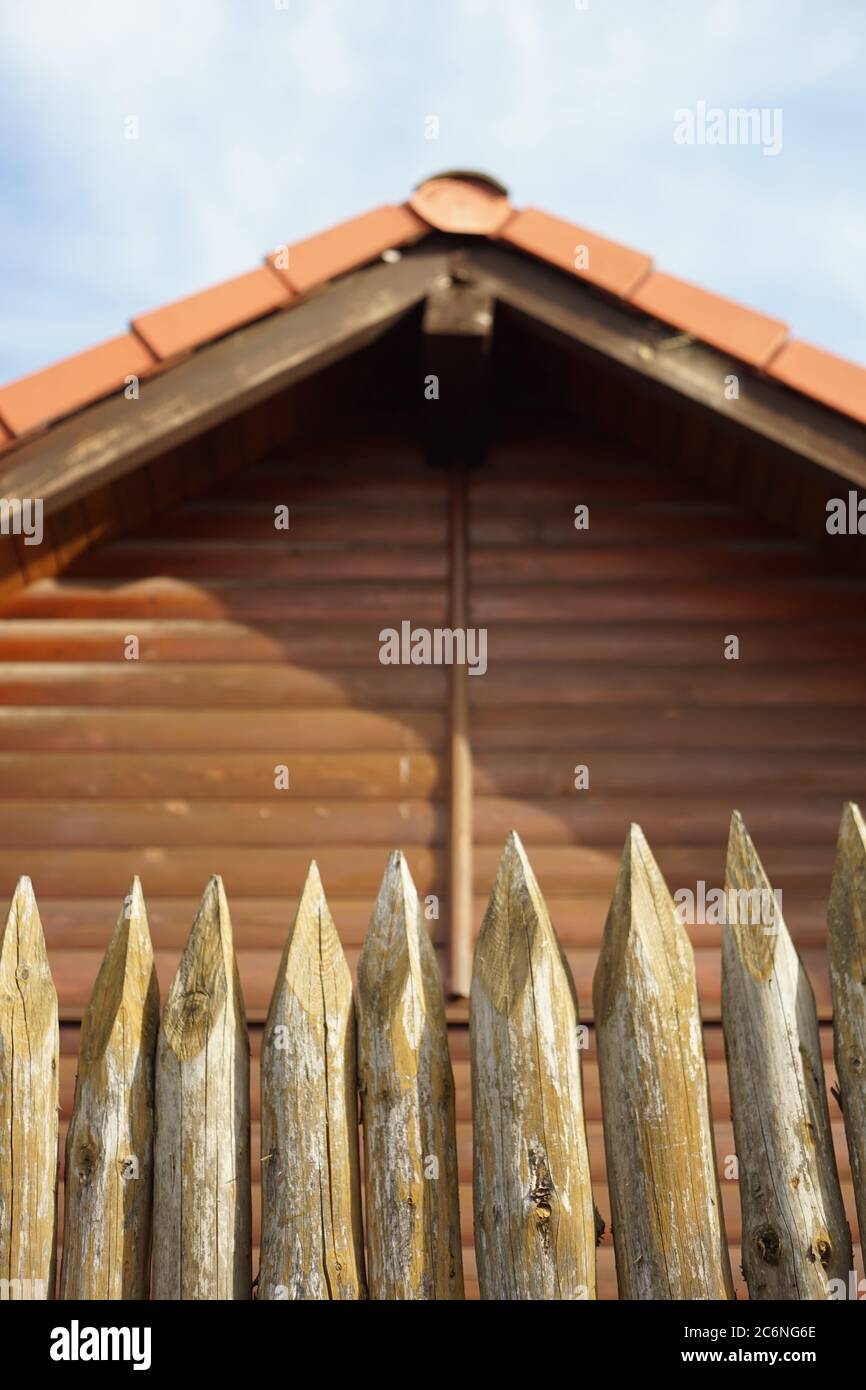 Picket wooden sharp fence closeup. Background blurred roof Stock Photo - Alamy