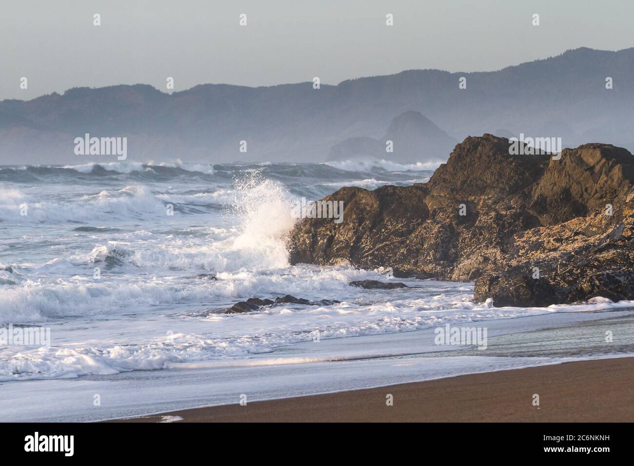 Rocky shoreline in Nesika Beach, Oregon late in the afternoon with the ...