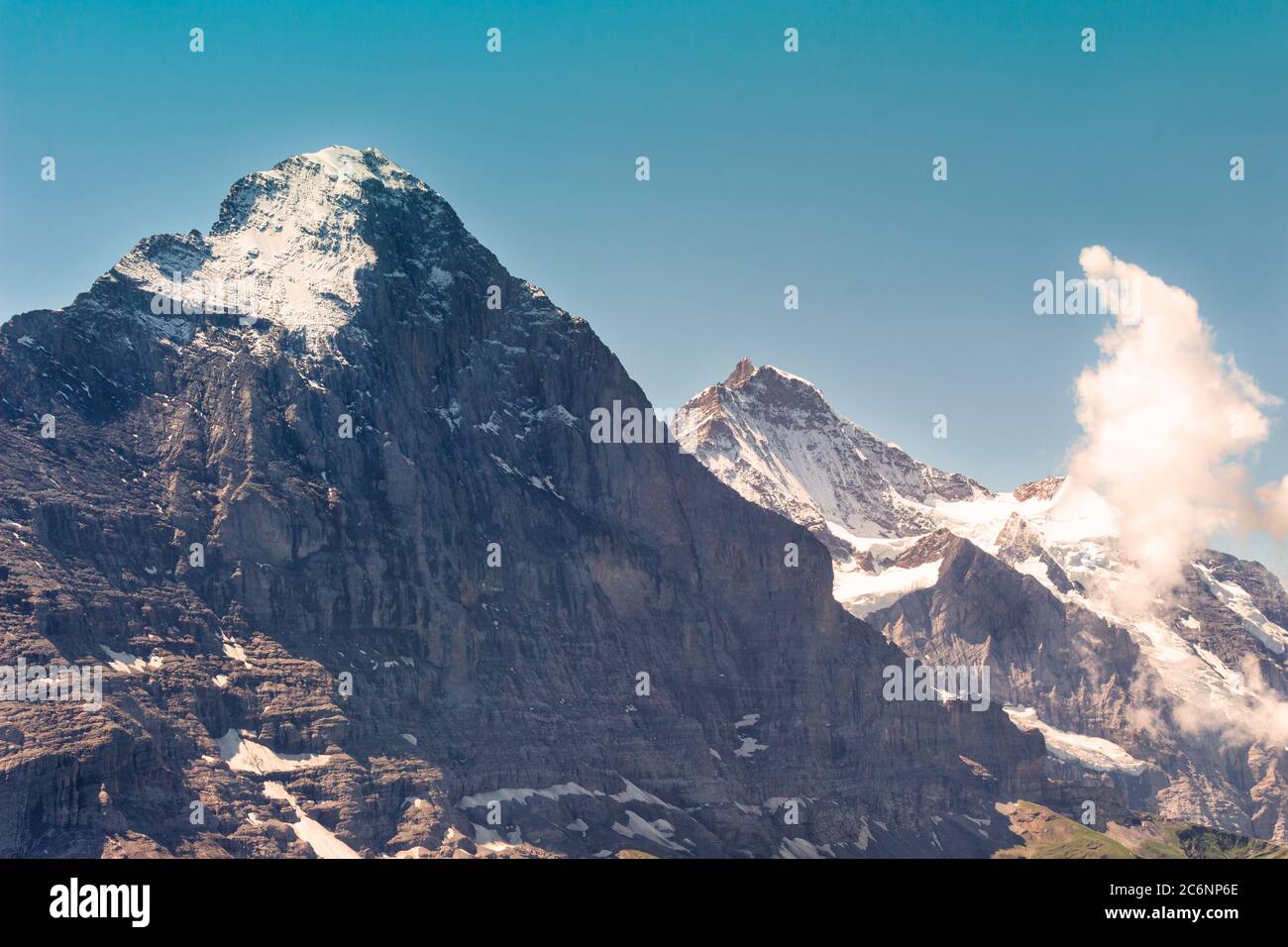 The Eiger north face and snow capped peak, in the background the top of ...