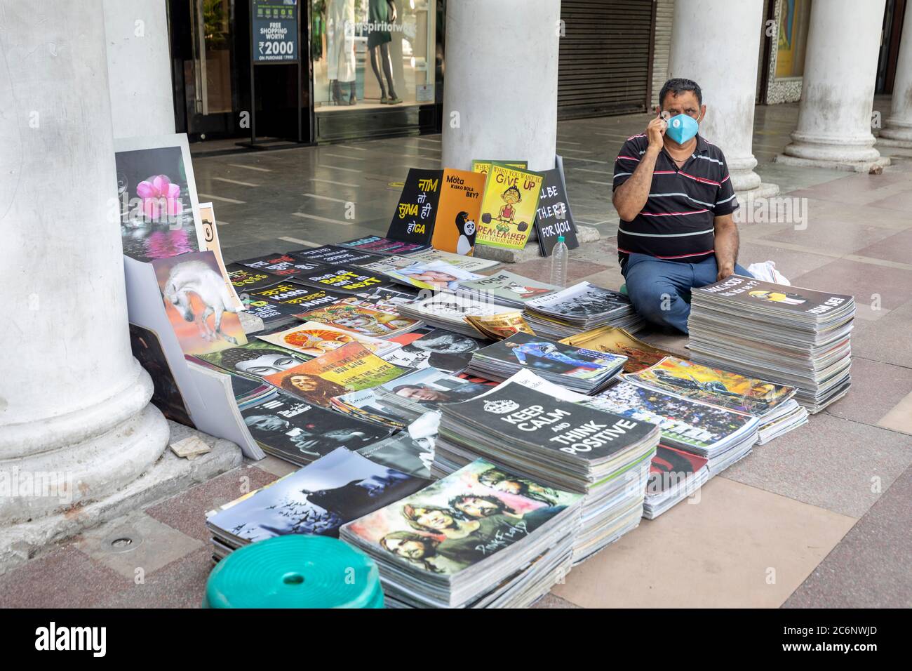 A street vendor wearing corona protection mask sitting in Connaught ...