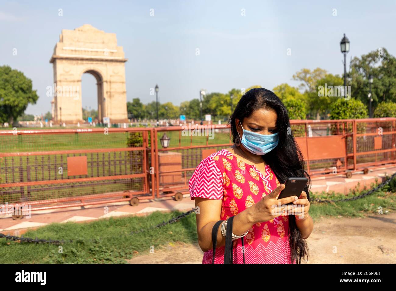 Indian woman standing infront of the iconic India Gate while wearing ...