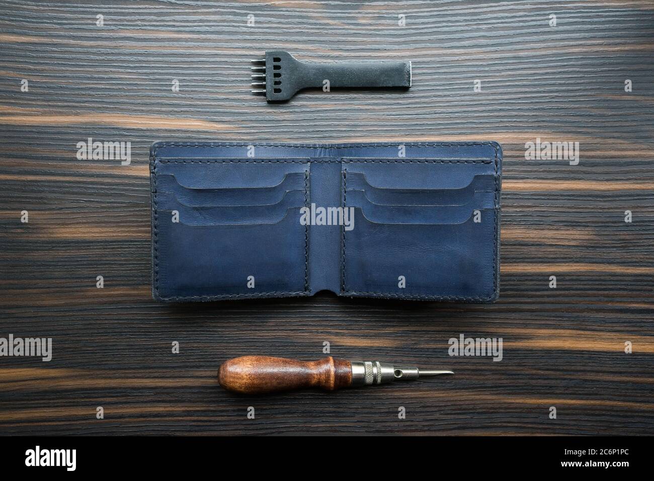 handmade blue leather wallet, punch and awl on a wooden table Stock ...