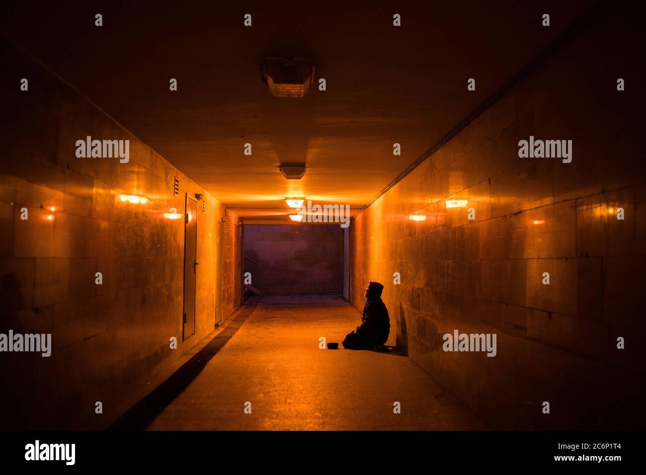 homeless beggar on his knees begs for alms in a dark underpass Stock ...