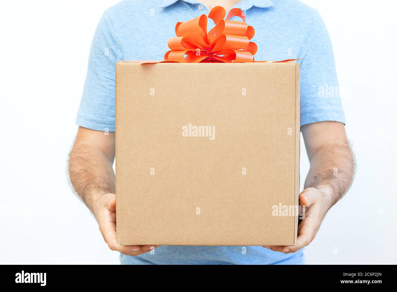 Men's hands hold a box with a red ribbon on a white background ...