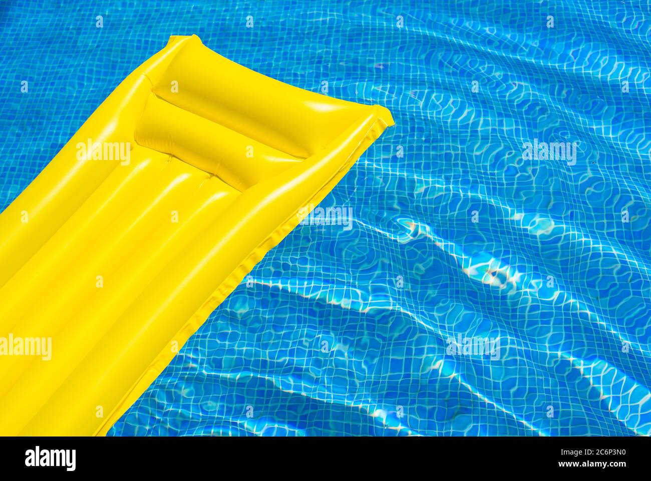 Yellow inflatable pool raft air bed in wavy swimming pool water Stock ...