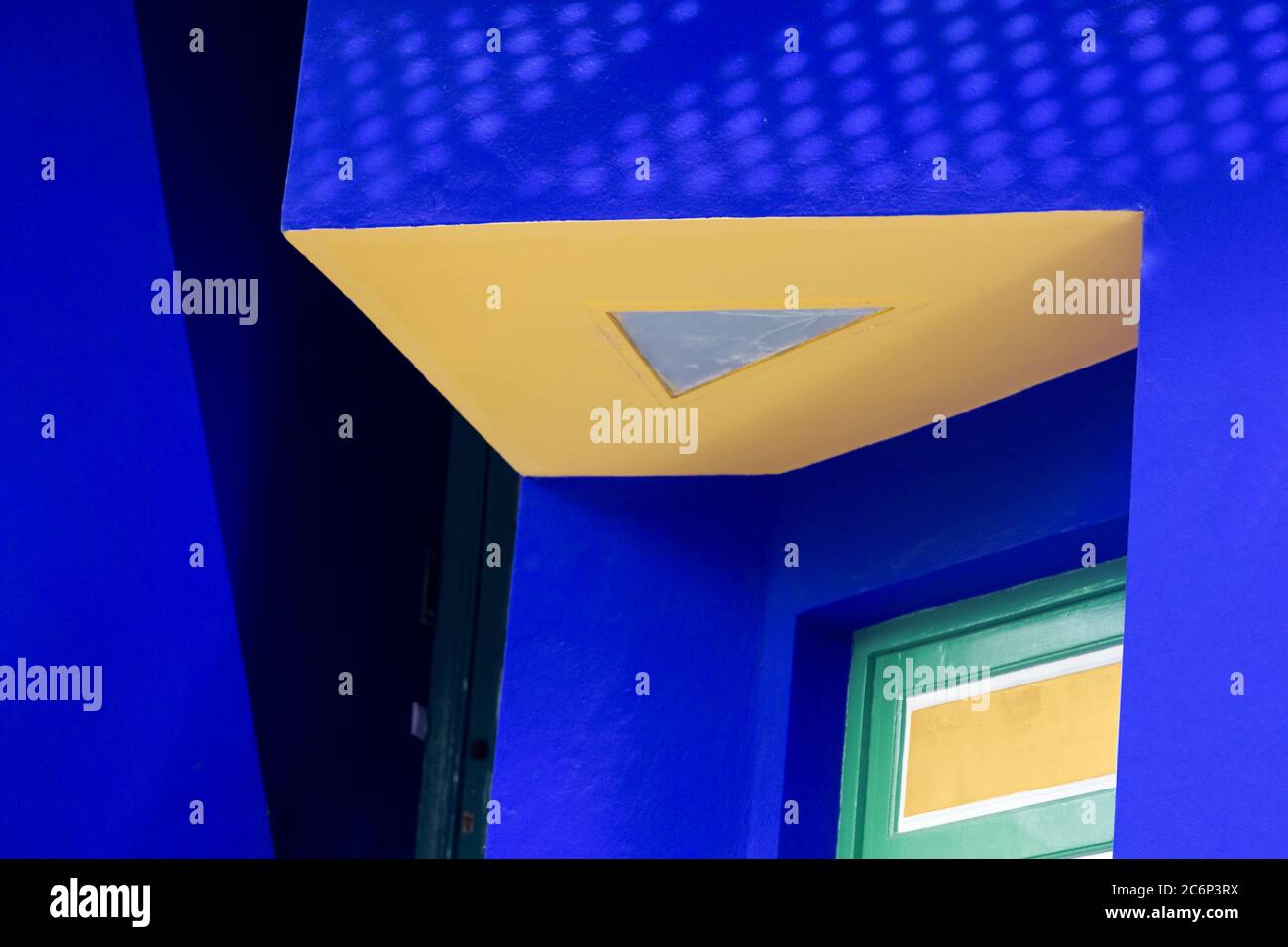 Colorfully painted house facade forming interesting pattern and shadows ...