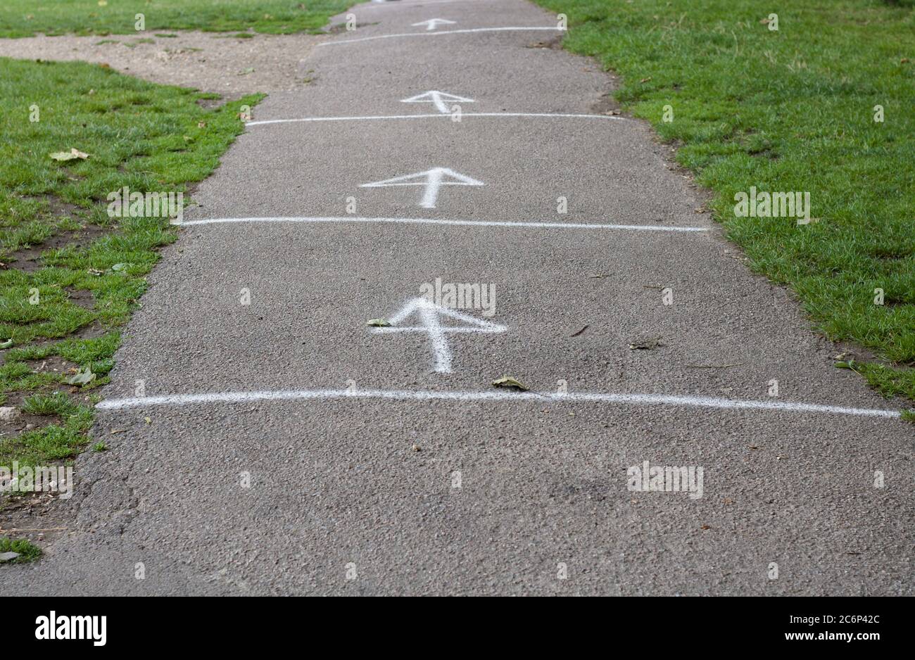 Social distancing arrows in coronavirus pandemic on path with grass ...
