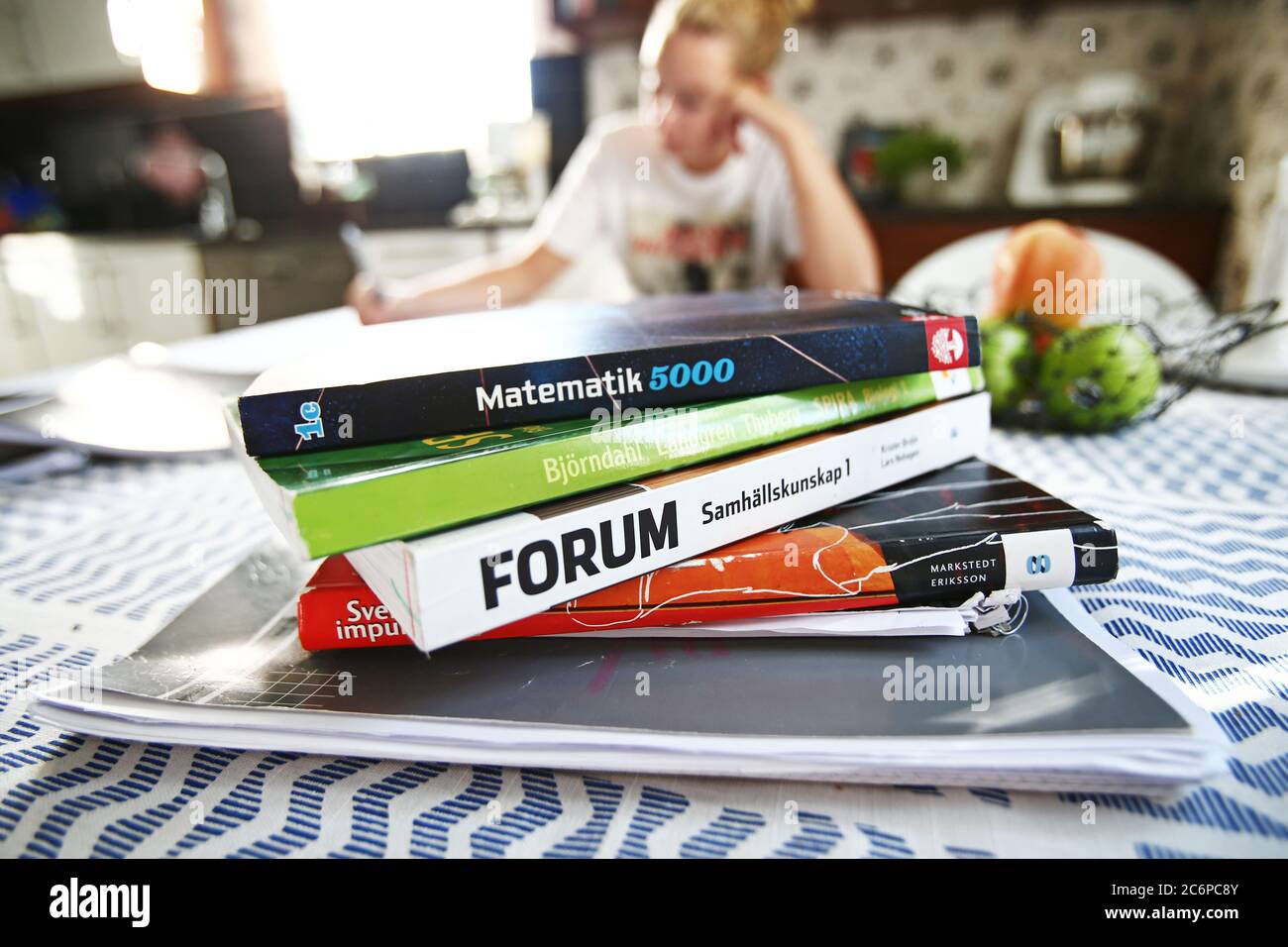 High school student doing her homework at a kitchen table.Photo by ...
