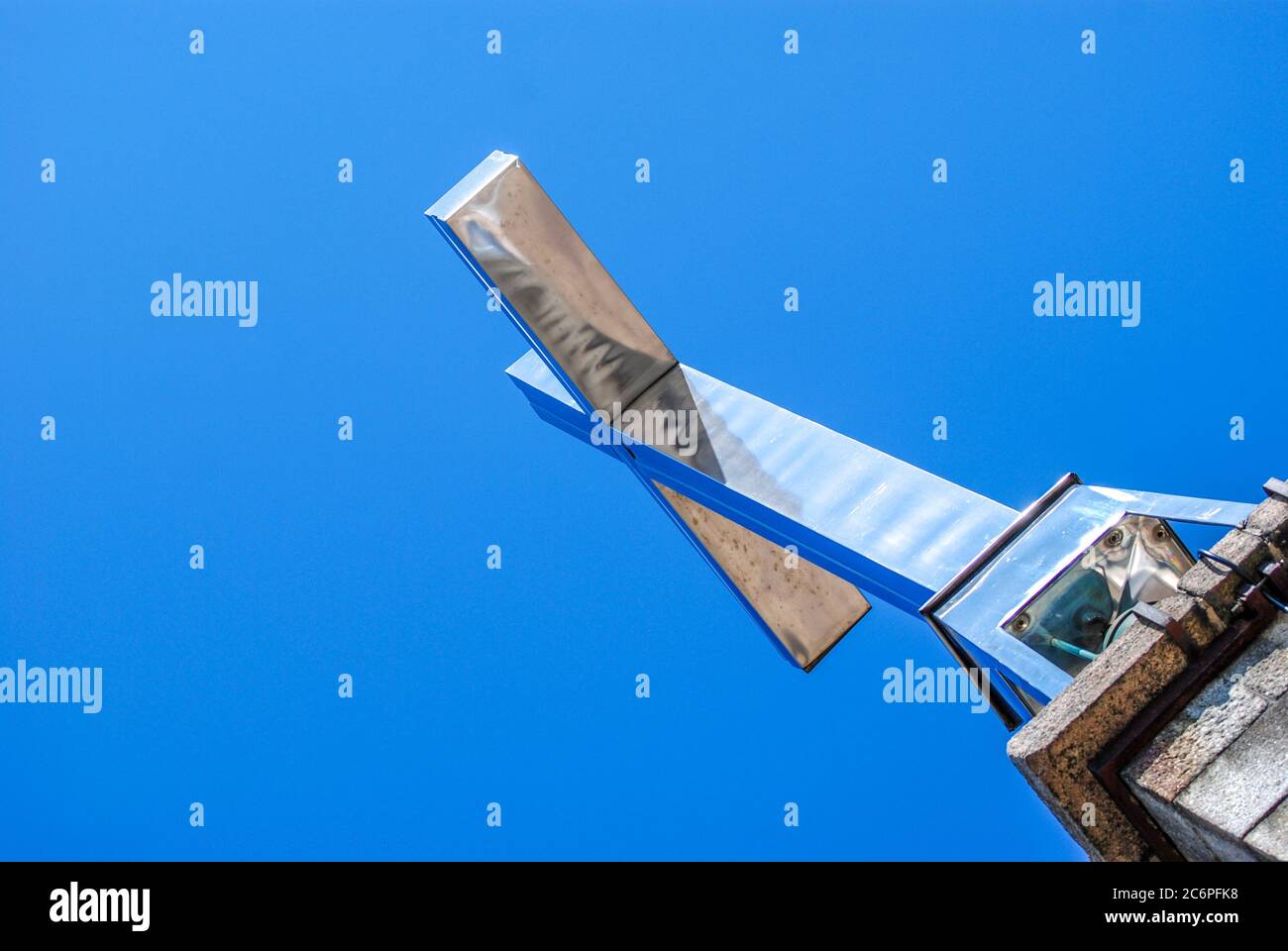 A shiny and reflective cross viewed against blue sky Stock Photo - Alamy