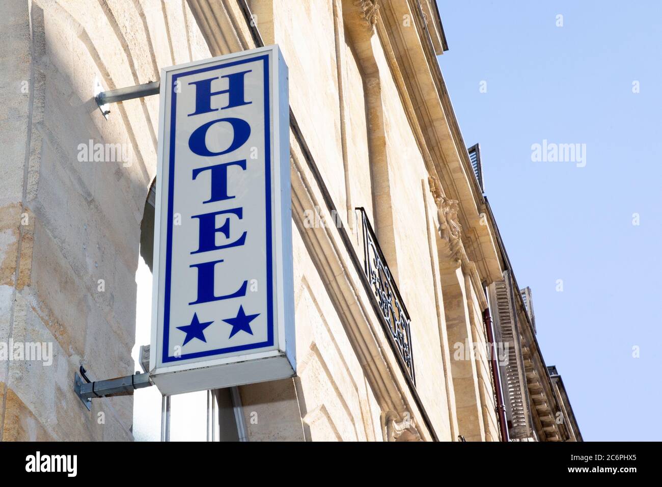 Hotel sign write in blue with two stars on white background in facade ...