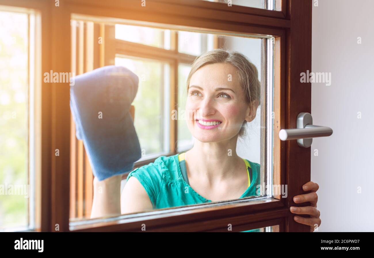 Beautiful woman cleaning the windows in spring Stock Photo - Alamy