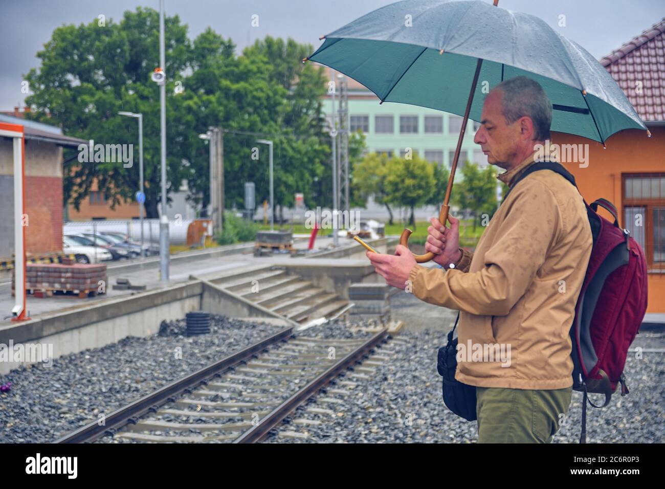 Portrait of a mature traveller with an umbrella standing on the ...