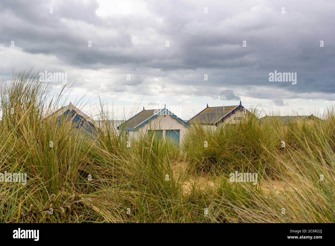 Sand dunes and beach huts Stock Photo - Alamy