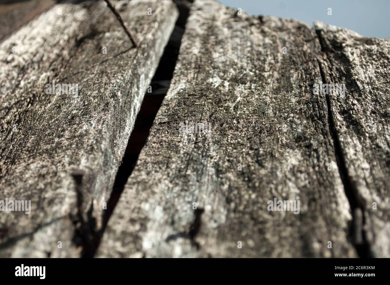 old rotten wooden roof with a nail on the sky background, old damaged ...