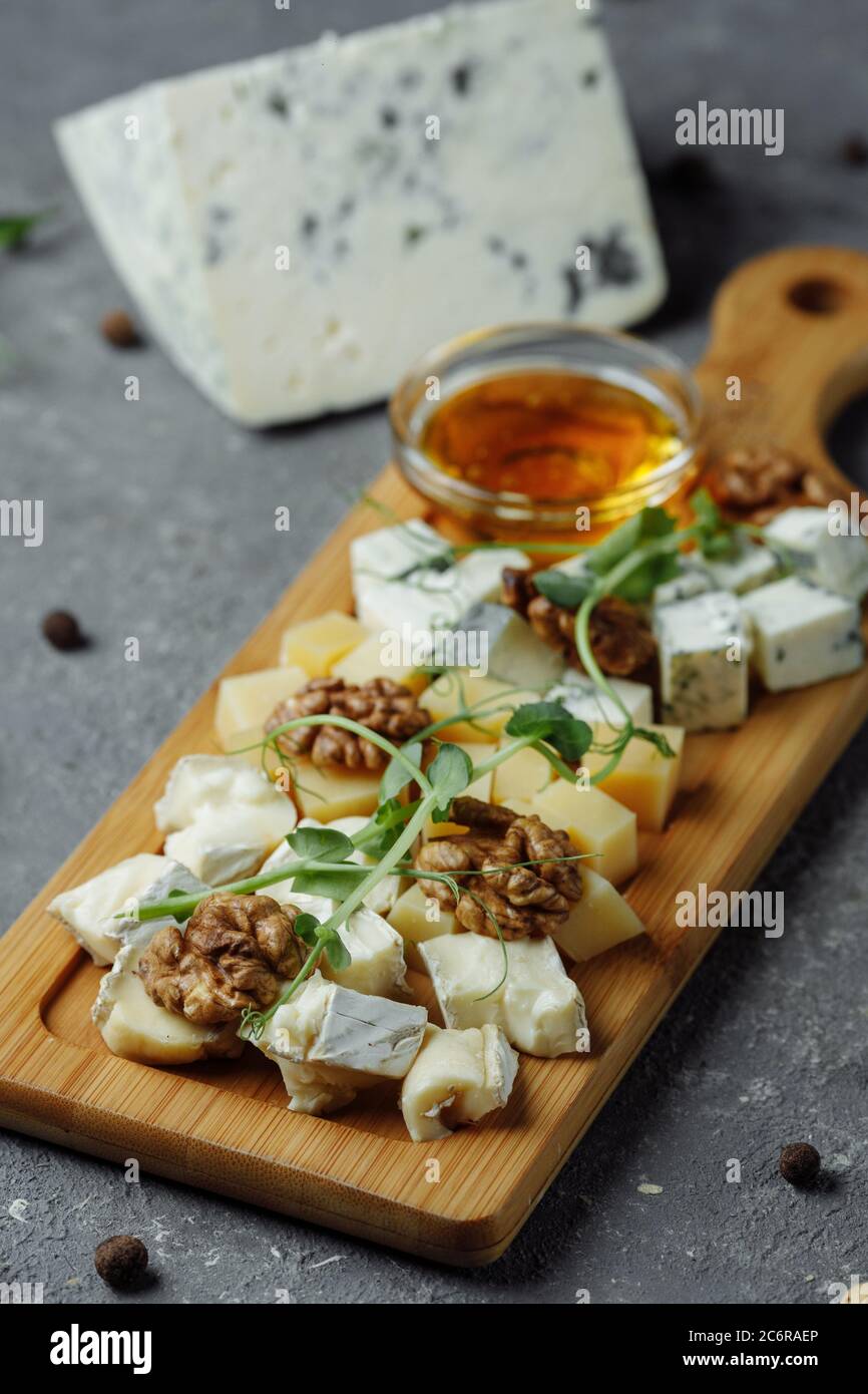 Close-up of a cheese plate. 4 types of cheese, soft white brie cheese ...