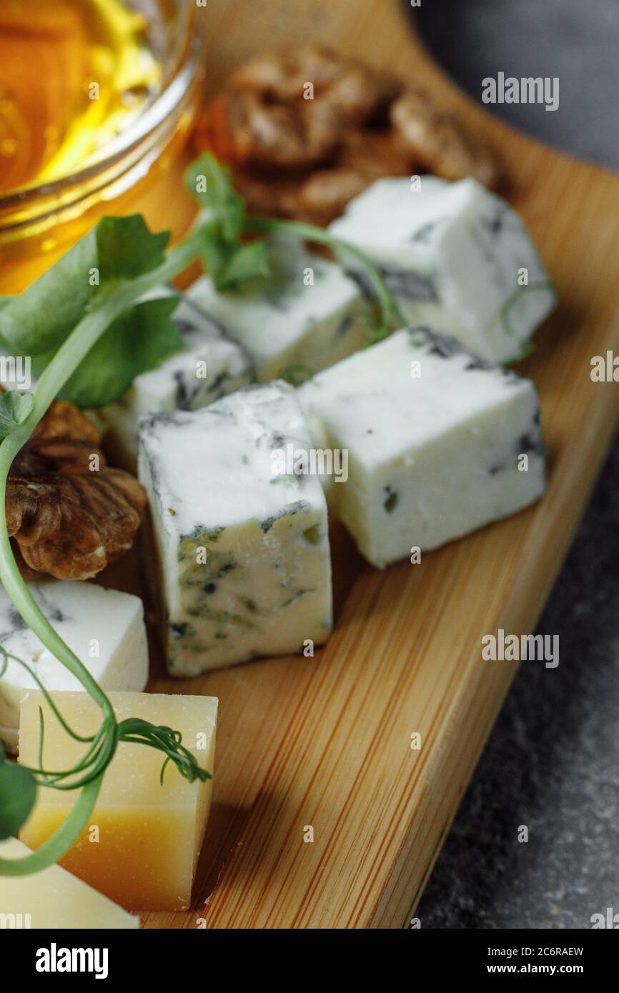Close-up of a cheese plate. 4 types of cheese, soft white brie cheese ...