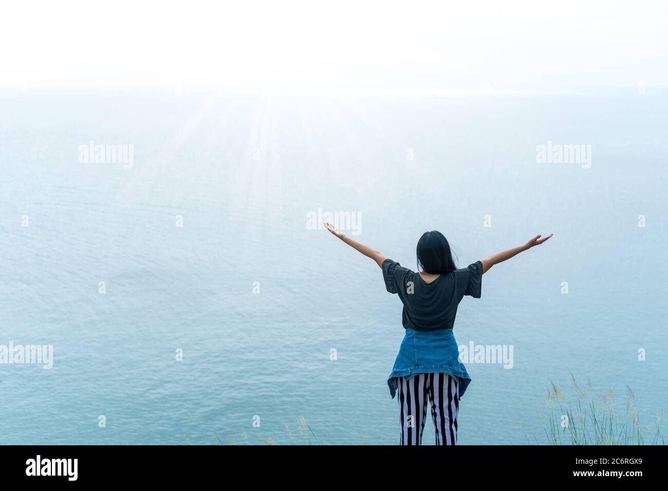 Woman rise hands up to sky freedom concept with blue sky and summer ...