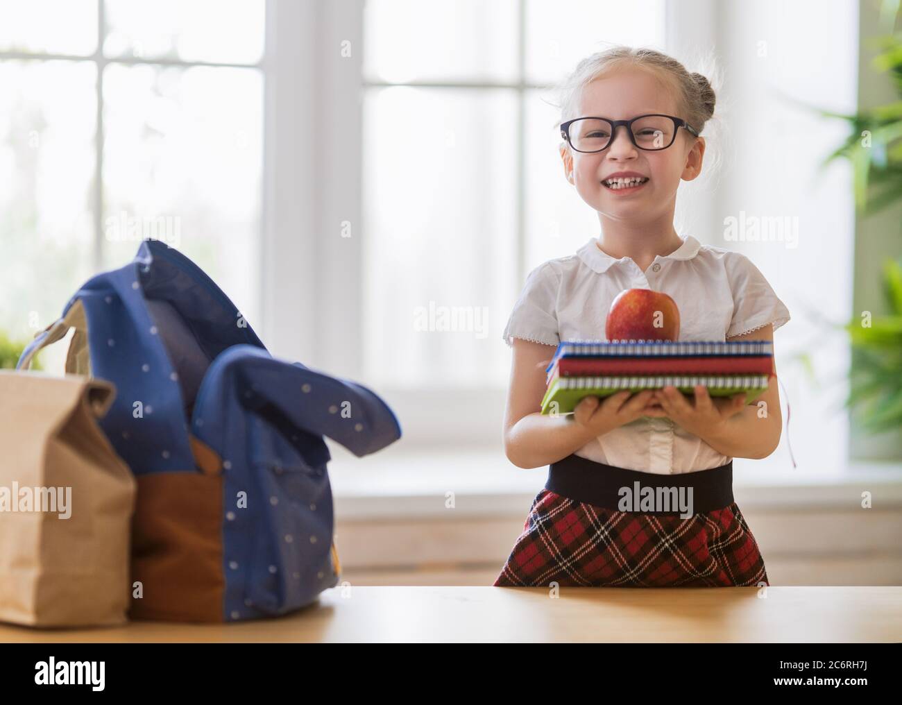 Happy child preparing for school. Little girl is putting things into ...