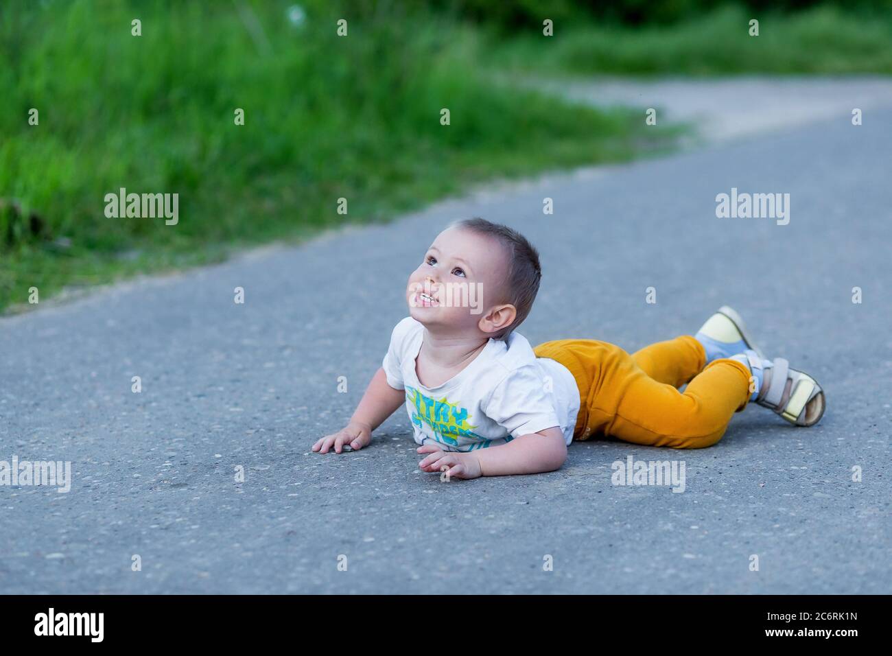 Cute toddler boy fell on park road Stock Photo - Alamy