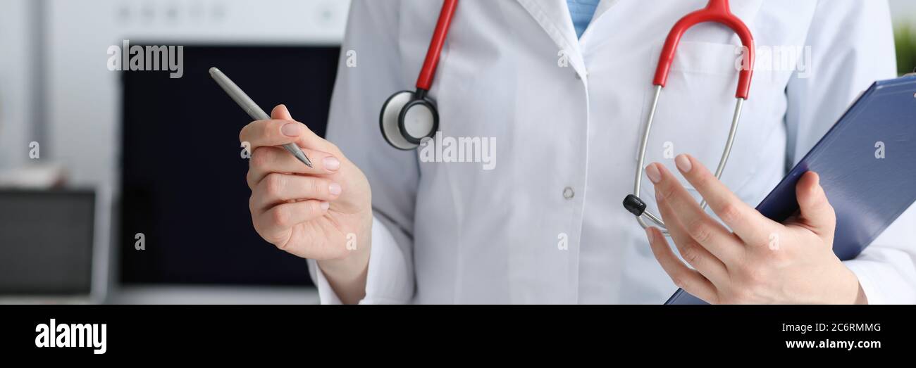 Female doctor is standing office holding folder Stock Photo - Alamy