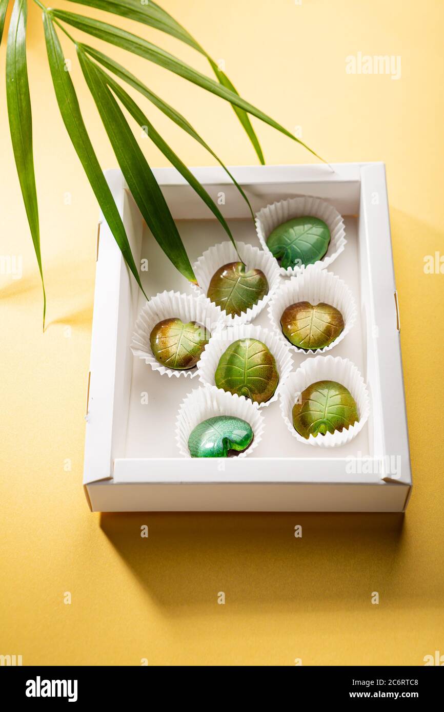 Green chocolate candies in goft box on yellow background Stock Photo ...