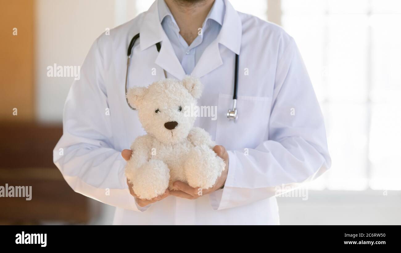 Close up male doctor holding fluffy toy, children healthcare concept ...