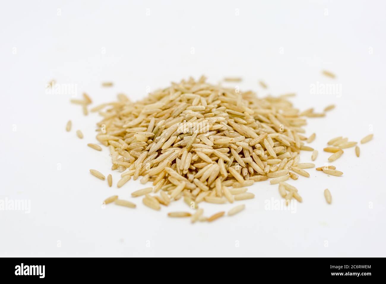 A pile of uncooked brown rice against a white background Stock Photo ...