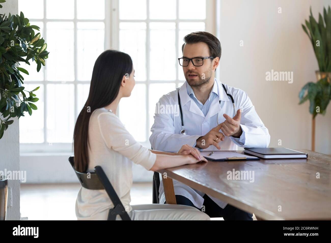 Serious doctor consulting female patient at meeting in clinic Stock ...