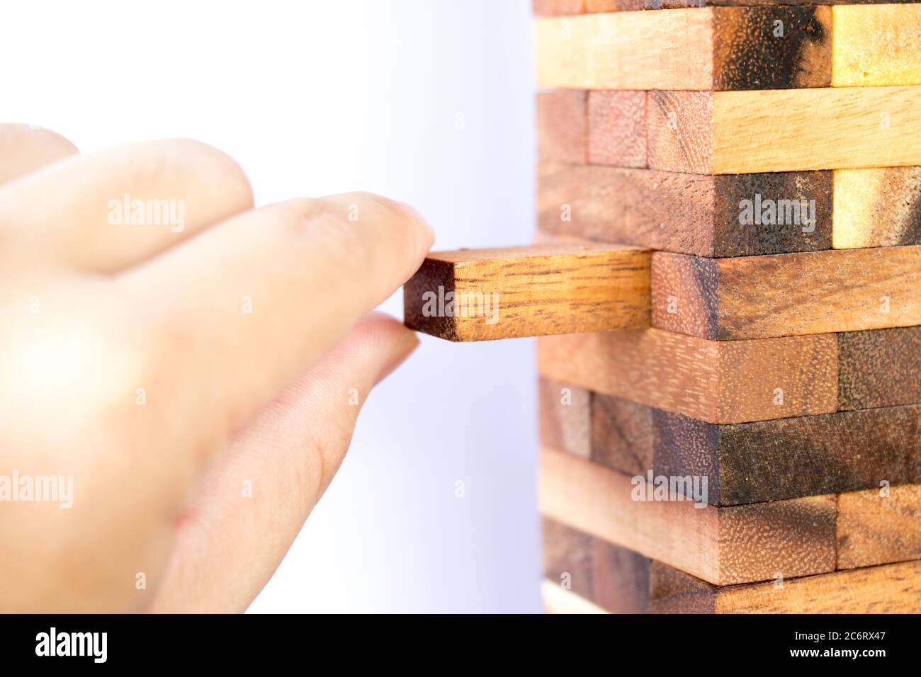 Hand hold wood block out of the stack up as tower on white background ...