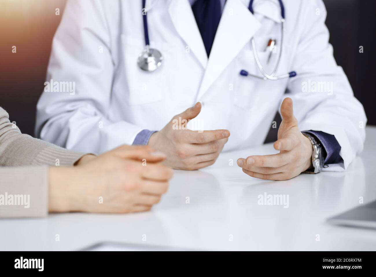 Unknown male doctor and patient woman discussing something while ...