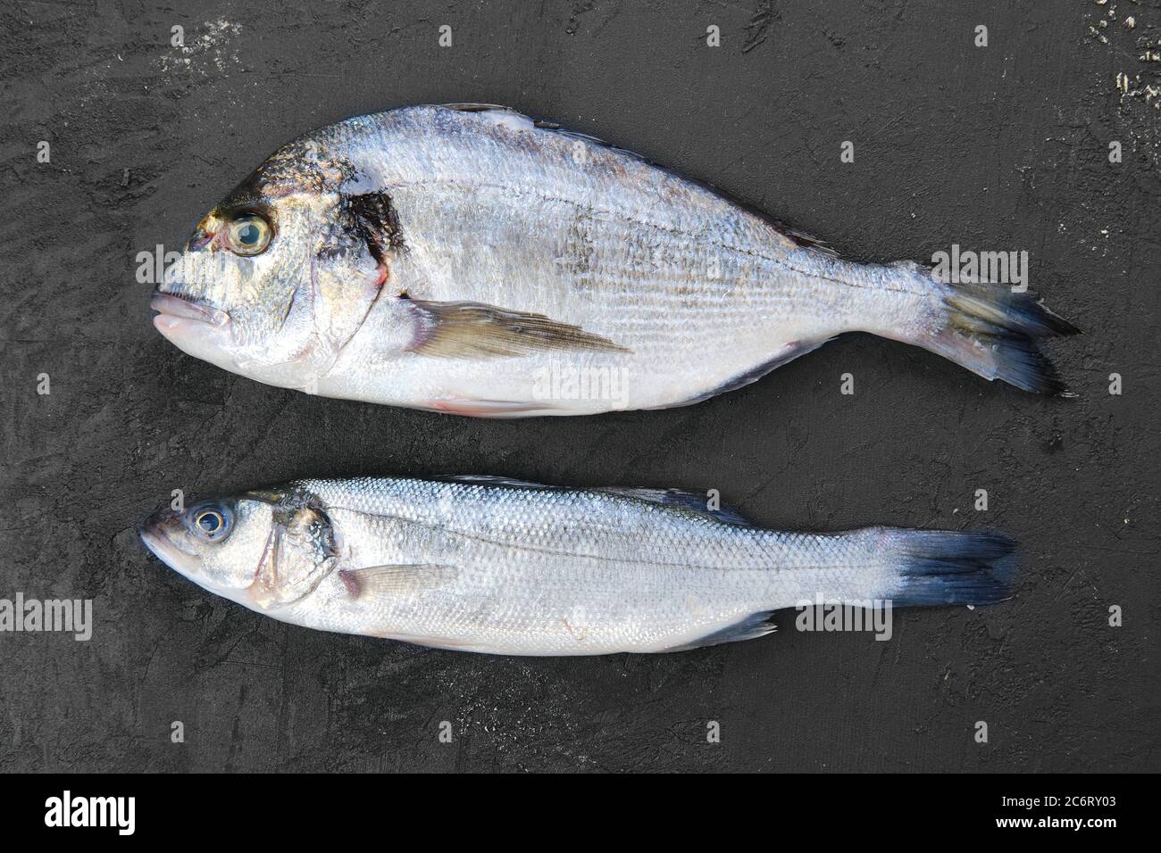 Fresh seabass and seabream fish on black stone background Stock Photo ...