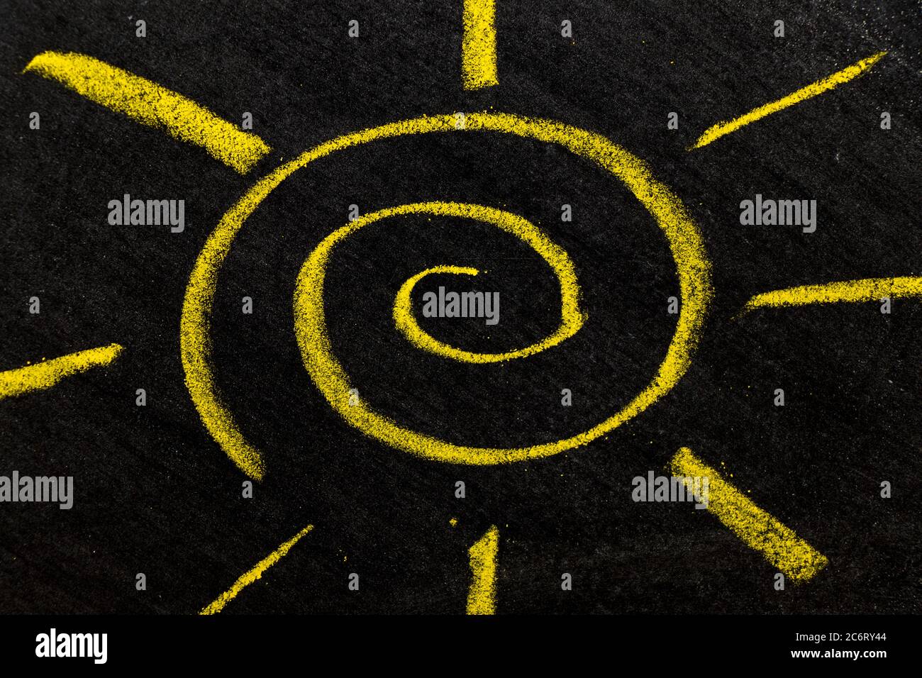 Yellow color chalk hand drawing as sun with light ray shape on black ...
