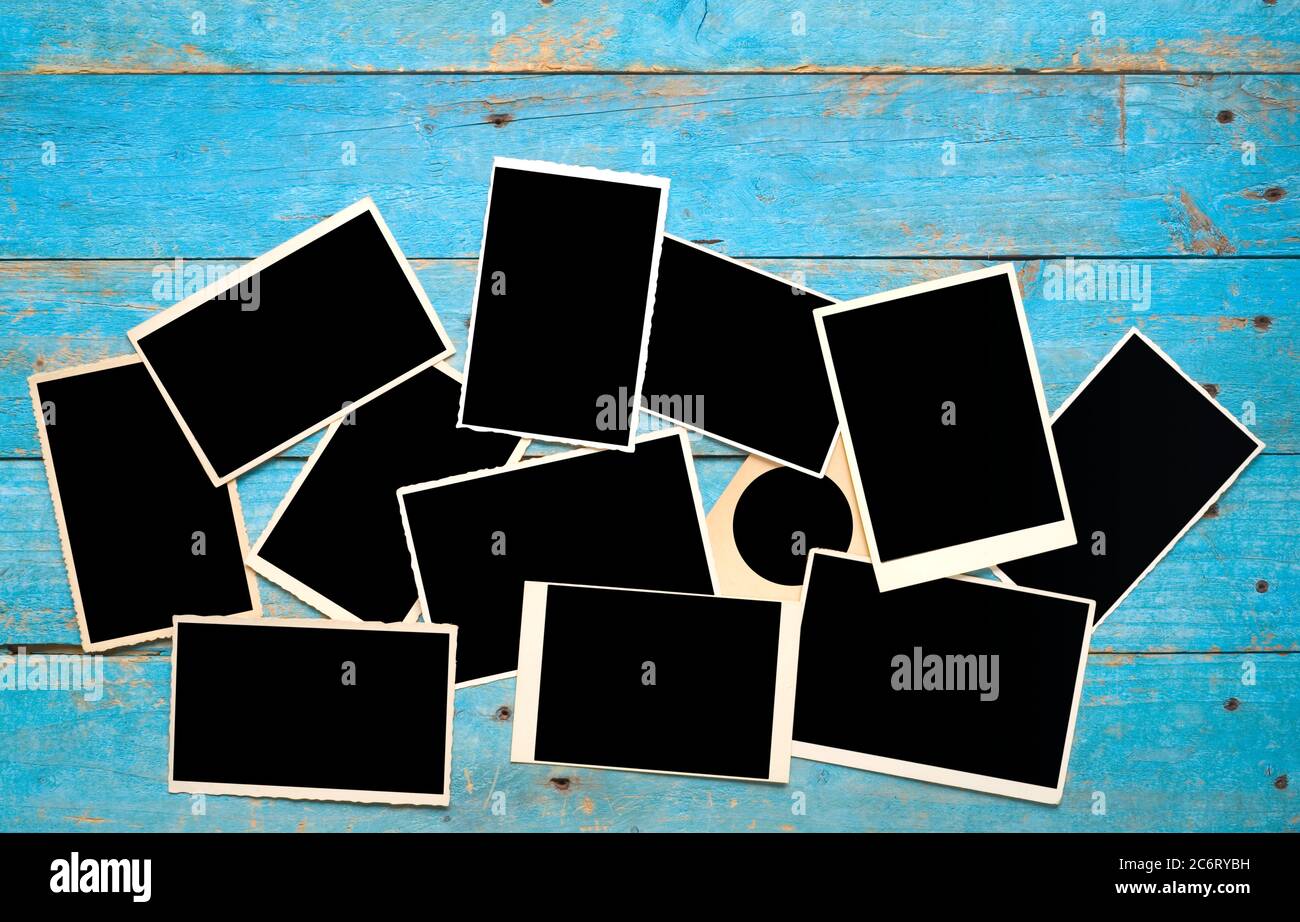 old empty photo frames, vintage photo prints on rough wooden surface ...