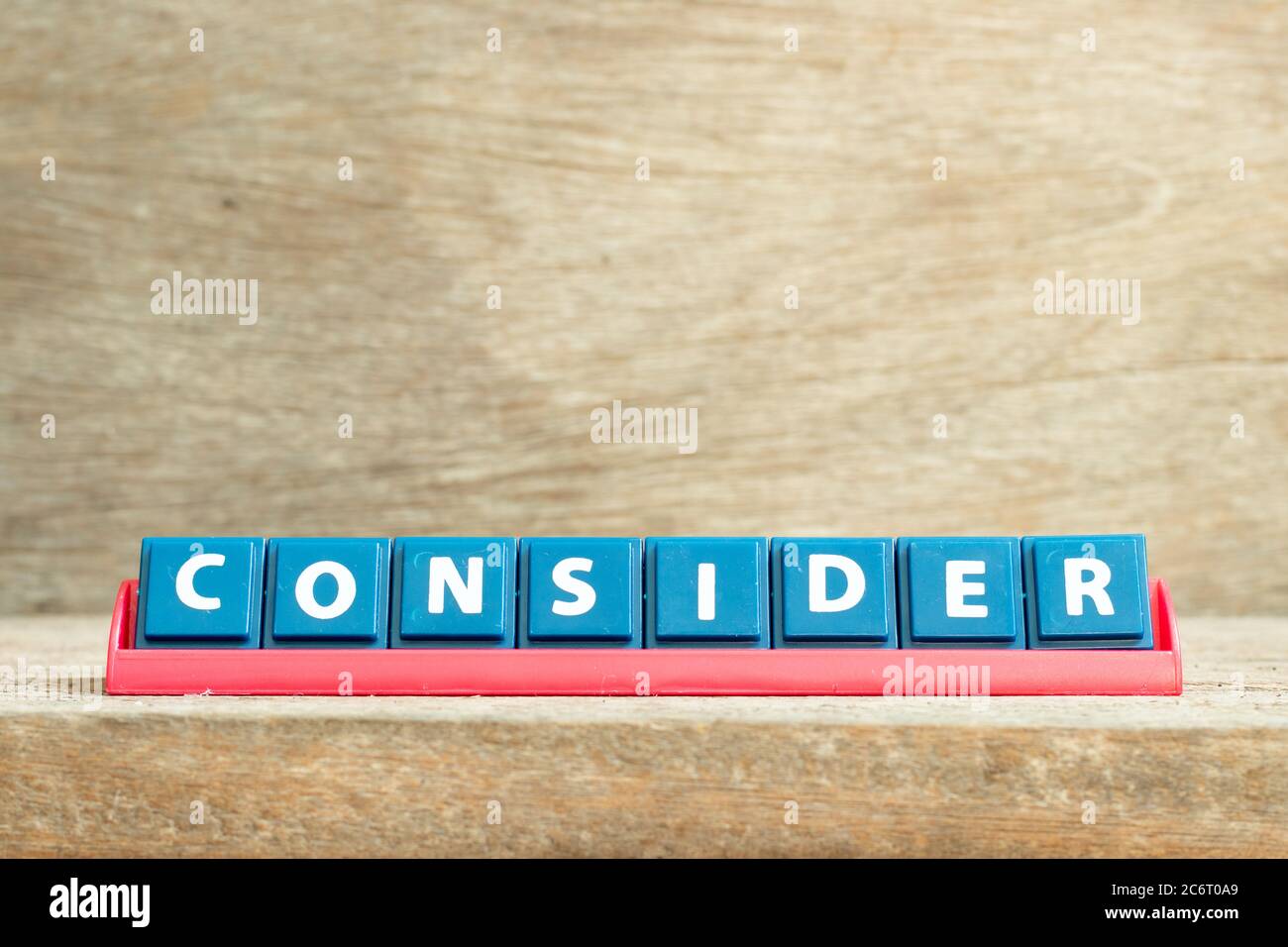 Tile letter on red rack in word consider on wood background Stock Photo ...