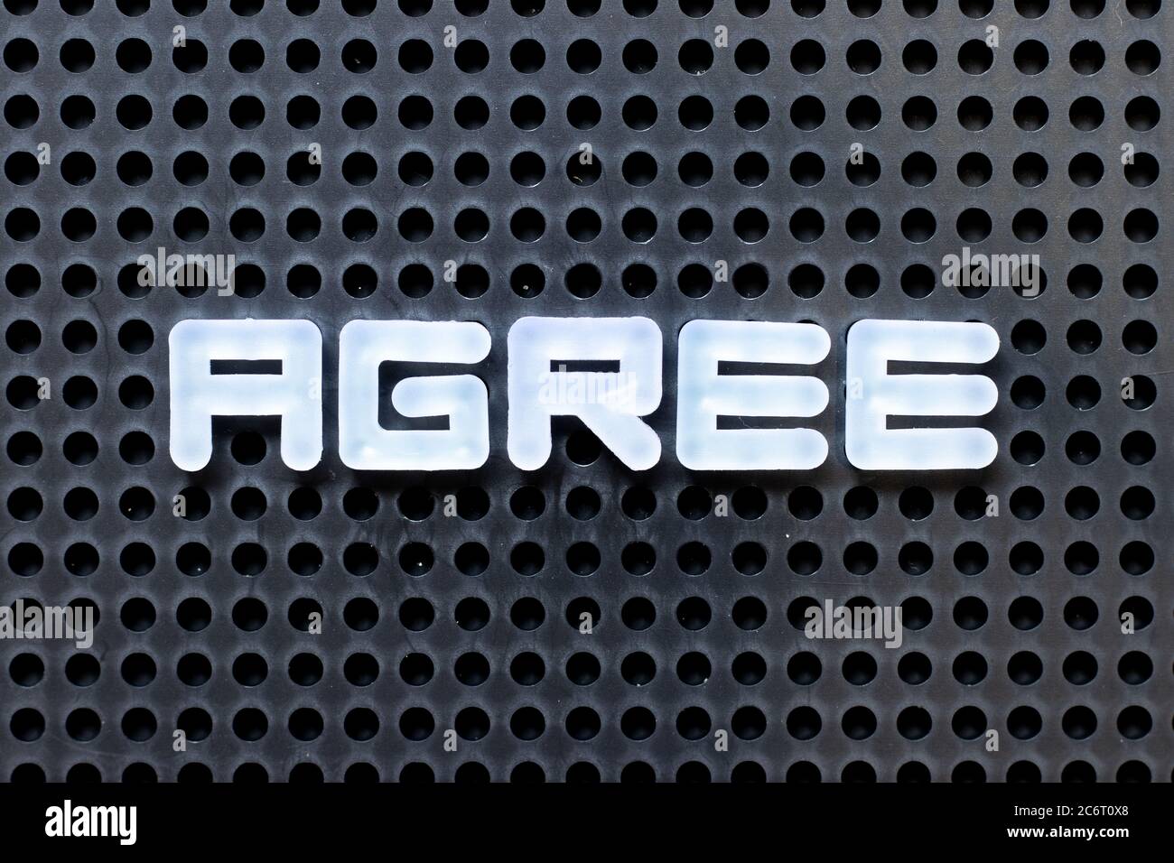 White color alphabet with word agree on black pegboard background Stock ...