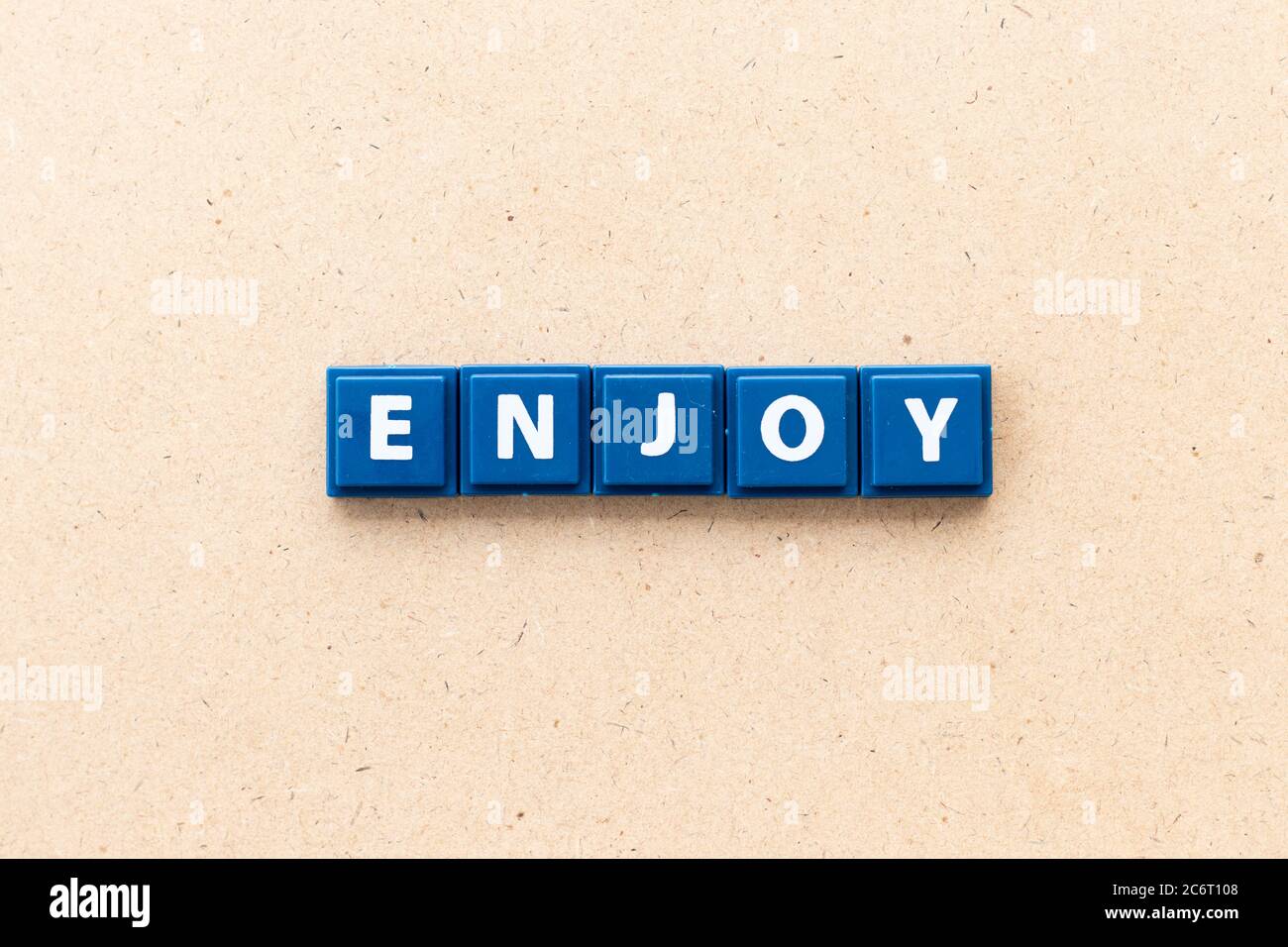 Tile letter in word enjoy on wood background Stock Photo - Alamy