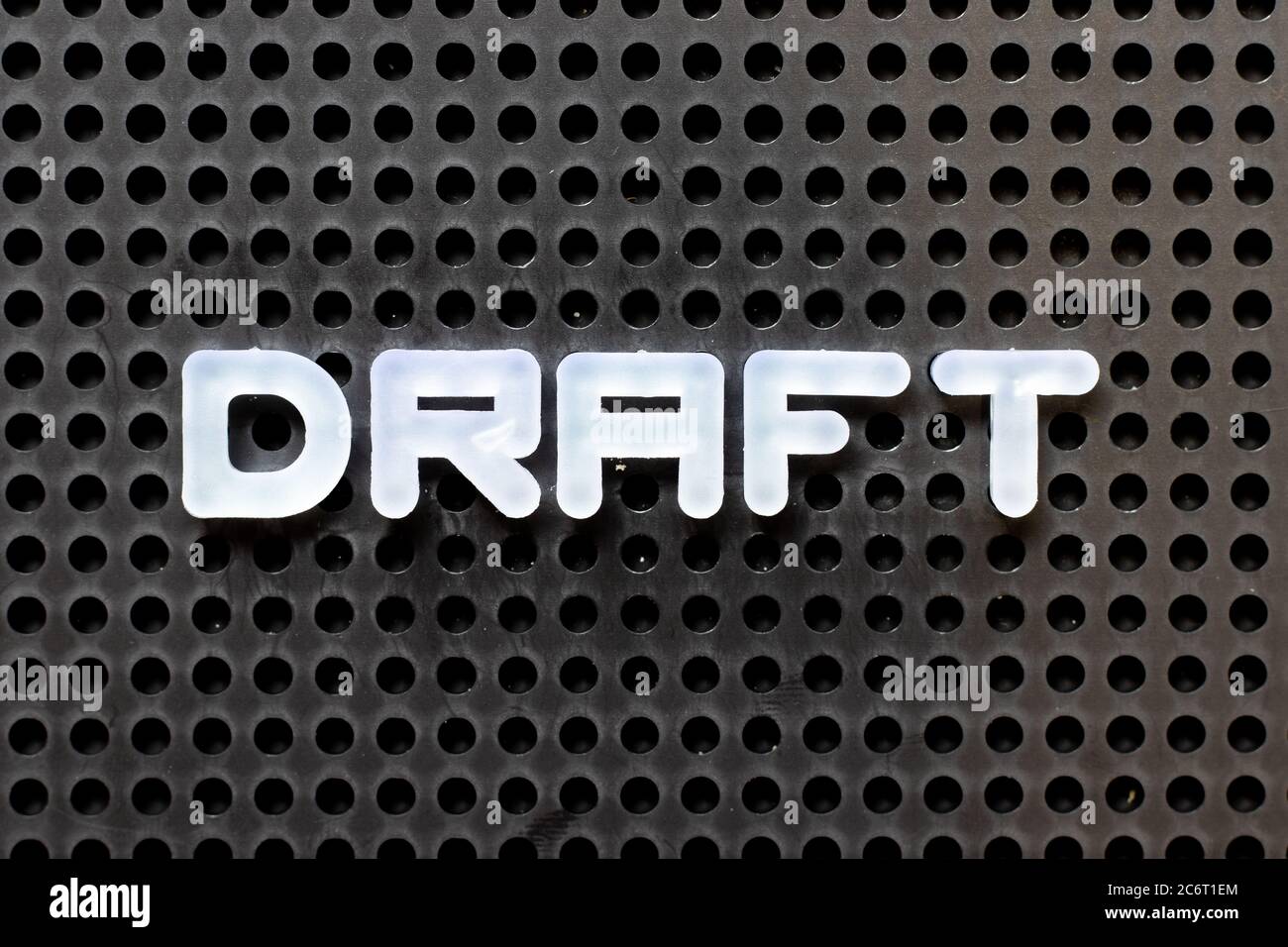 White color alphabet with word draft on black pegboard background Stock ...